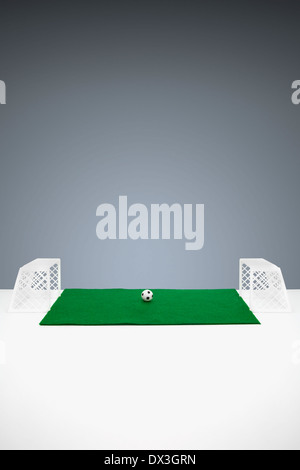 Small table top football goal posts, football and green felt pitch on ...