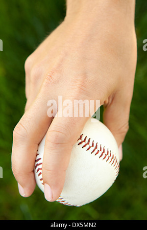 Baseball pitcher, close up of the hand ready to pitch on white wooden ...