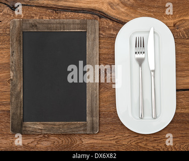 Menu blackboard on oak wooden background top view and gray napkin ...