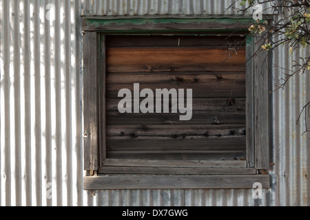 Corrugated metal wall with window and boarded-up door Stock Photo - Alamy