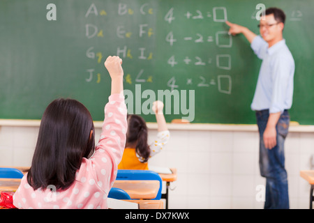 group of smart students raise hands up in school classroom on class ...