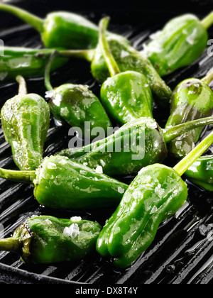 Cooked grilled patron peppers, or hebron peppers, on a black griddle ...