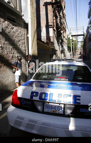 A Vancouver Police Department cop speaks to a person in an alley in ...