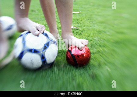 Two children's legs with balls Stock Photo - Alamy