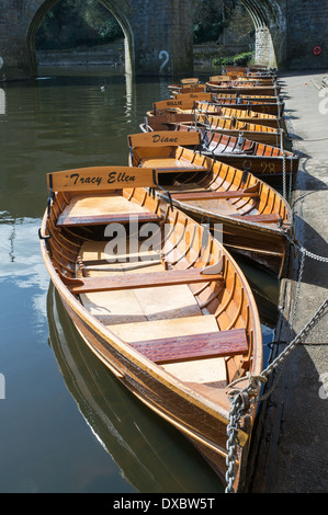 Line of moored rowing boats on the banks of River Wear near a boat club ...