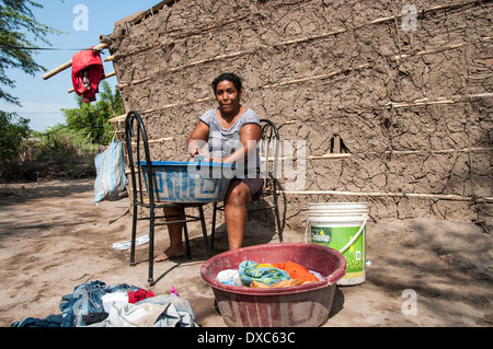 Afro-Peruvian woman washing clothes in her home, village of Yapatera ...