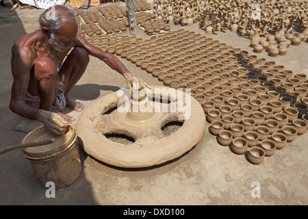 Potter making pots on a traditional wheel with special clay. Kumhartoli ...