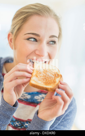 Woman eating toast Stock Photo - Alamy