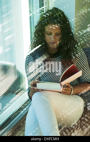 Teenaged girl sitting next to window Stock Photo - Alamy