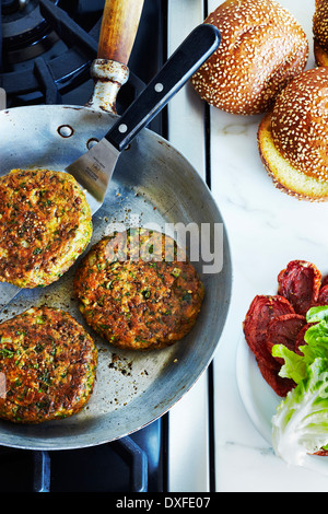 An angle top shot of a burger on a plate with onion rings and french ...