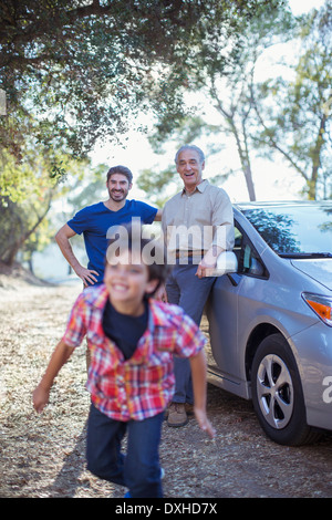 Vertical image of happy three generation caucasian men walking in ...