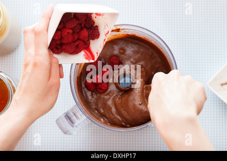 Chocolate cake recipe. Mixing cake batter in a glass bowl. Close up ...