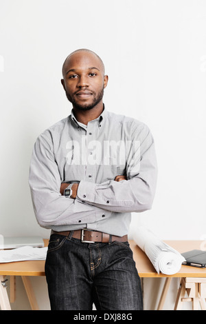 Portrait of confident young Black IT engineer in cardigan standing with ...