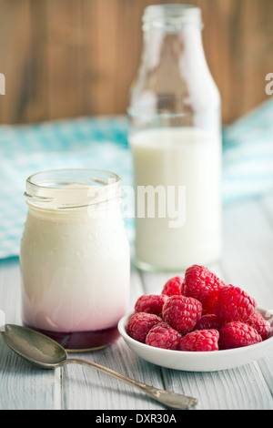 Wooden retro spoon in a jar full of plum jam on a desk. Close up ...