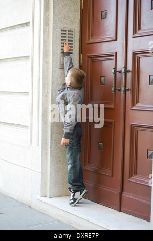 Young boy ringing doorbell Stock Photo - Alamy