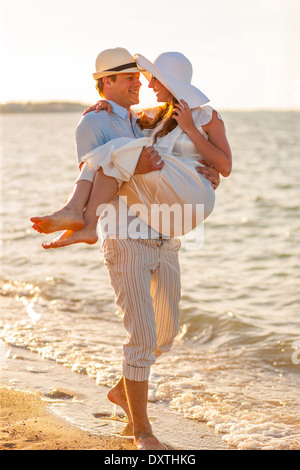 young groom carrying bride over threshold, portrait Stock Photo - Alamy