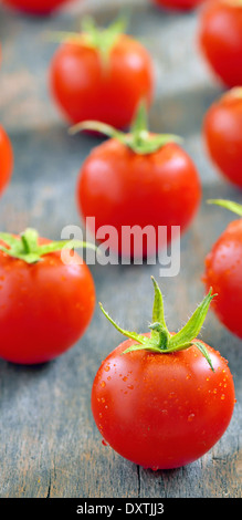 Fresh cherry tomatoes in a wooden bowl isolated on a blue background ...