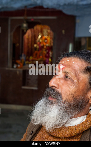 A Hindu ascetic or holy man, seated under a tree, receiving food from a ...