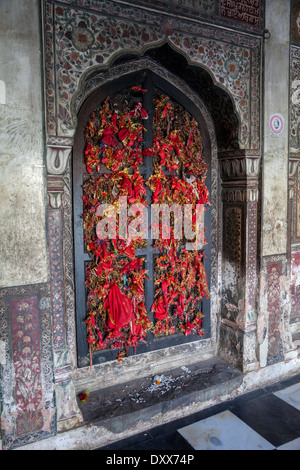 India, Dehradun. Visitors tie bits of red cloth to the window ...