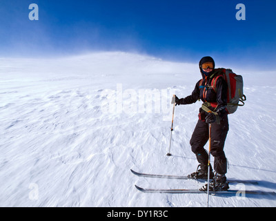 ski touring in the Rondane, Norway. Vast snow covered mountains dwarf ...