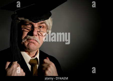 Old style, English headmaster with mortar board and flexing his cane ...