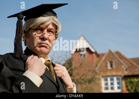 Old style, English headmaster with mortar board and flexing his cane ...