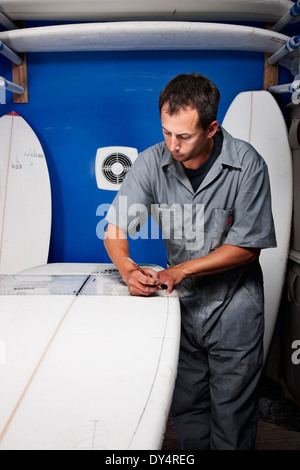 Man measuring with ruler on surfboard Stock Photo - Alamy
