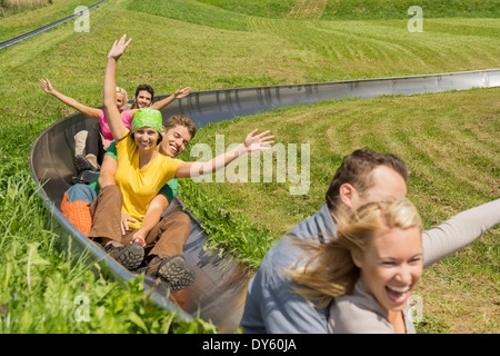 Excited young couples enjoying alpine coaster luge during summer Stock ...