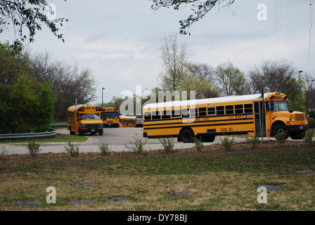 Yellow school buses leave a bus barn for the after noon trip from ...