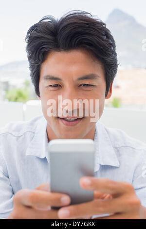 Handsome man sending a text Stock Photo - Alamy