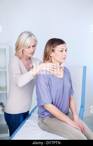 Woman palpation her neck, examine thyroid gland. Enlarged butterfly ...