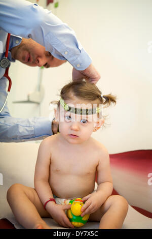 Pediatrician measuring the circumference of a 2 month old baby's head ...