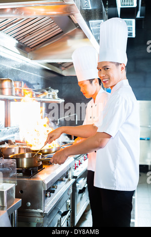 Side view of chefs cooking together Stock Photo - Alamy