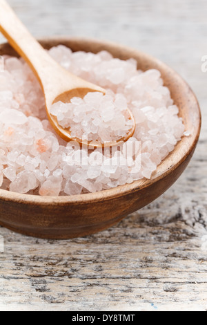 Himalayan pink salt in spoon on a wooden background, top view ...