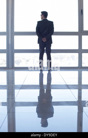 Man standing behind window, hands pressed against glass, looking Stock ...