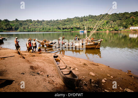 Manually offloading sand from a boat on the Mandovi River in Goa, India ...