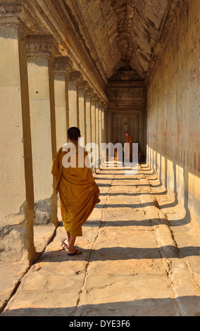 Visiting monks in yellow strolling among the bas-relief scenes from the ...