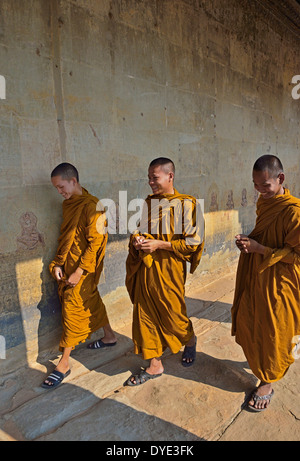 Visiting monks in yellow strolling among the bas-relief scenes from the ...