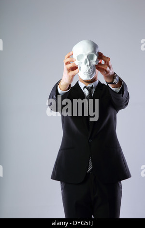 Businessman holding skull portrait, isolated on white Stock Photo - Alamy