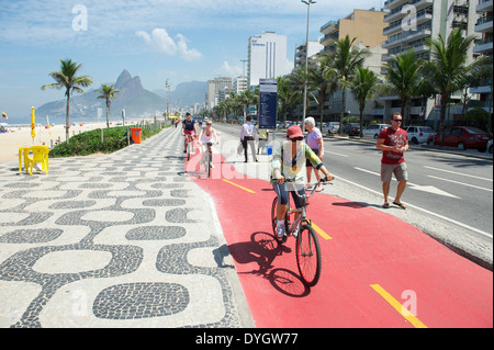Cyclist rides on the bike lane located next to the Copacabana beach ...