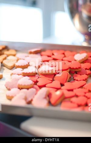 Heart shaped cookies on the pink plate on white wooden background. Flat ...