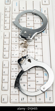 Computer keyboard and handcuffs. Cybercrime, internet security and ...