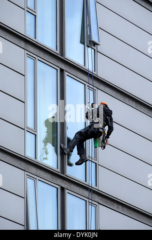 window cleaner hanging on rope at work on skyscraper Stock Photo - Alamy