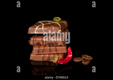 Luxurious chocolate with chilli pepper and coffee beans on black ...