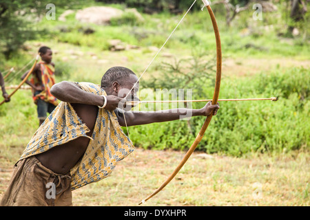 Young Hadza men practice hunting with bow and arrow Stock Photo - Alamy