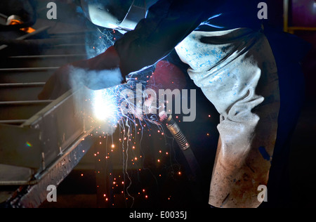 Worker with protective mask welding metal and producing smoke and ...