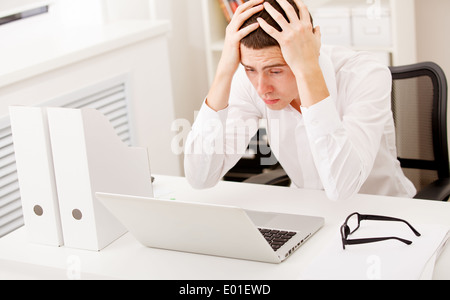 Despairing businessman sitting at desk Stock Photo - Alamy