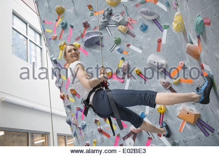 Woman climbing over over wall Stock Photo - Alamy