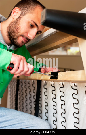 Man assembling sofa furniture at home Stock Photo - Alamy