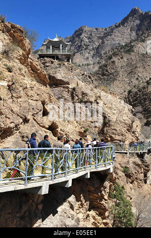 Tourists walk on the newly-built glass walkway along the edge of a ...